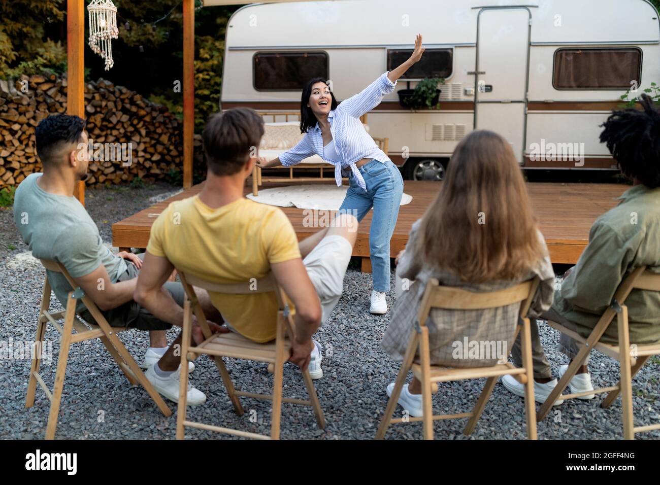 Joyful Asian lady playing word guessing game with diverse friends near ...