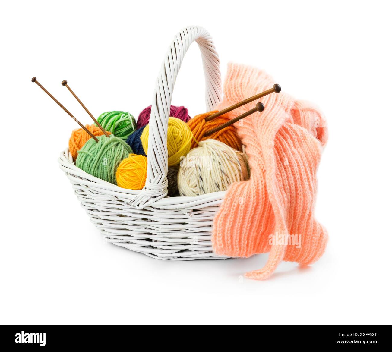 Balls of woolen threads for knitting in wicker basket isolated on white ...