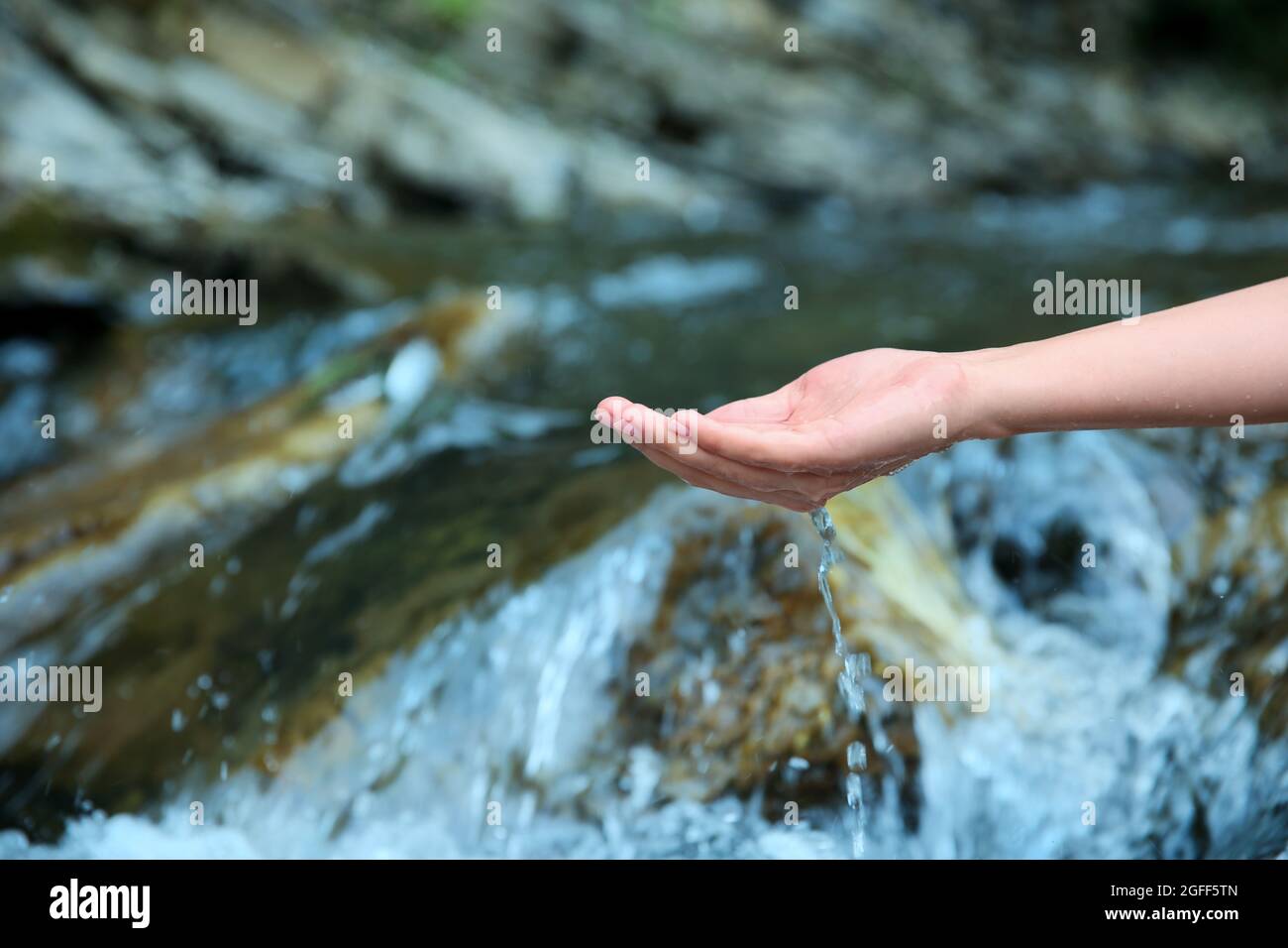 Female hand in water stream Stock Photo - Alamy