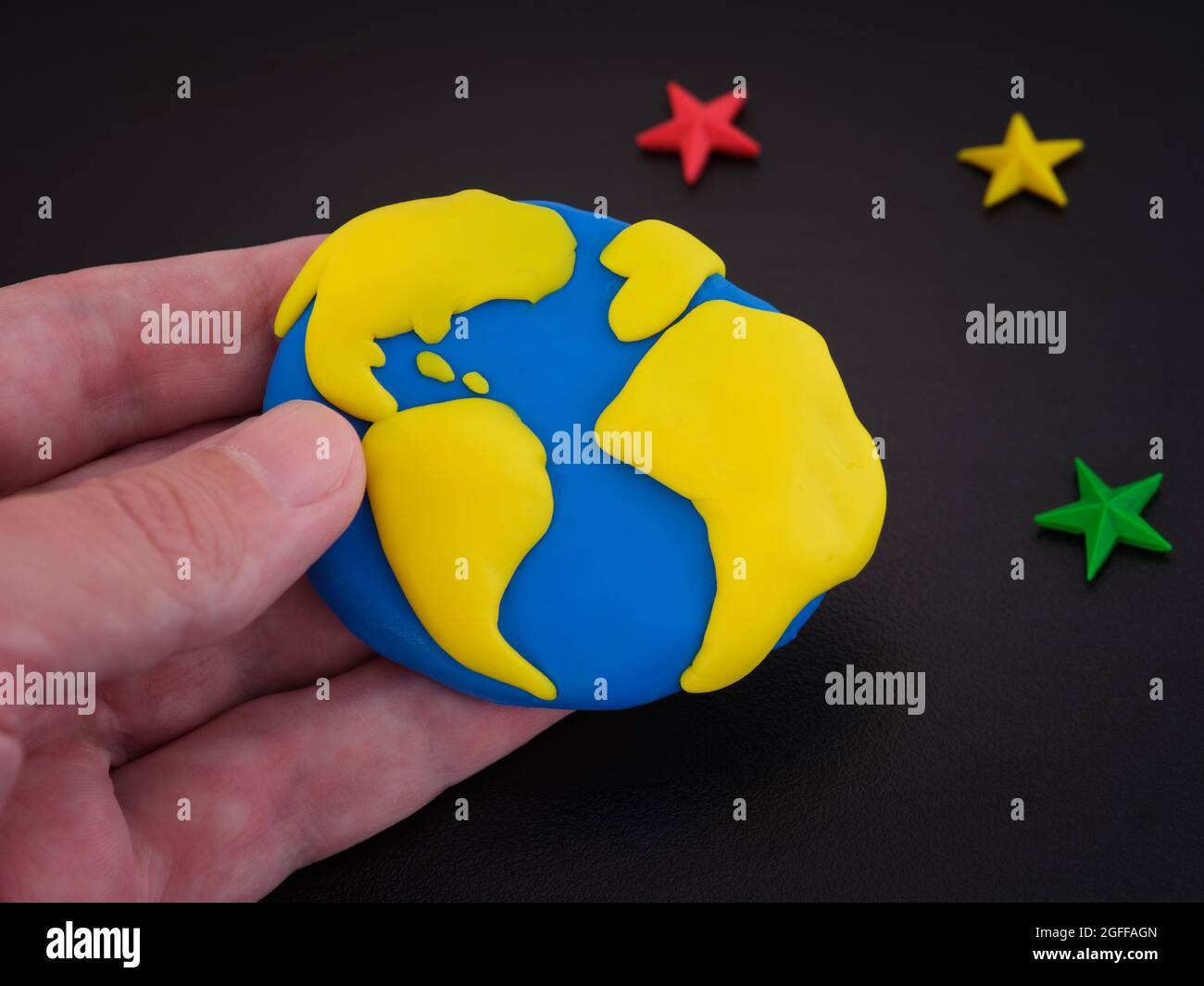 A man holding the planet Earth in his hand. The planet Earth is made ...