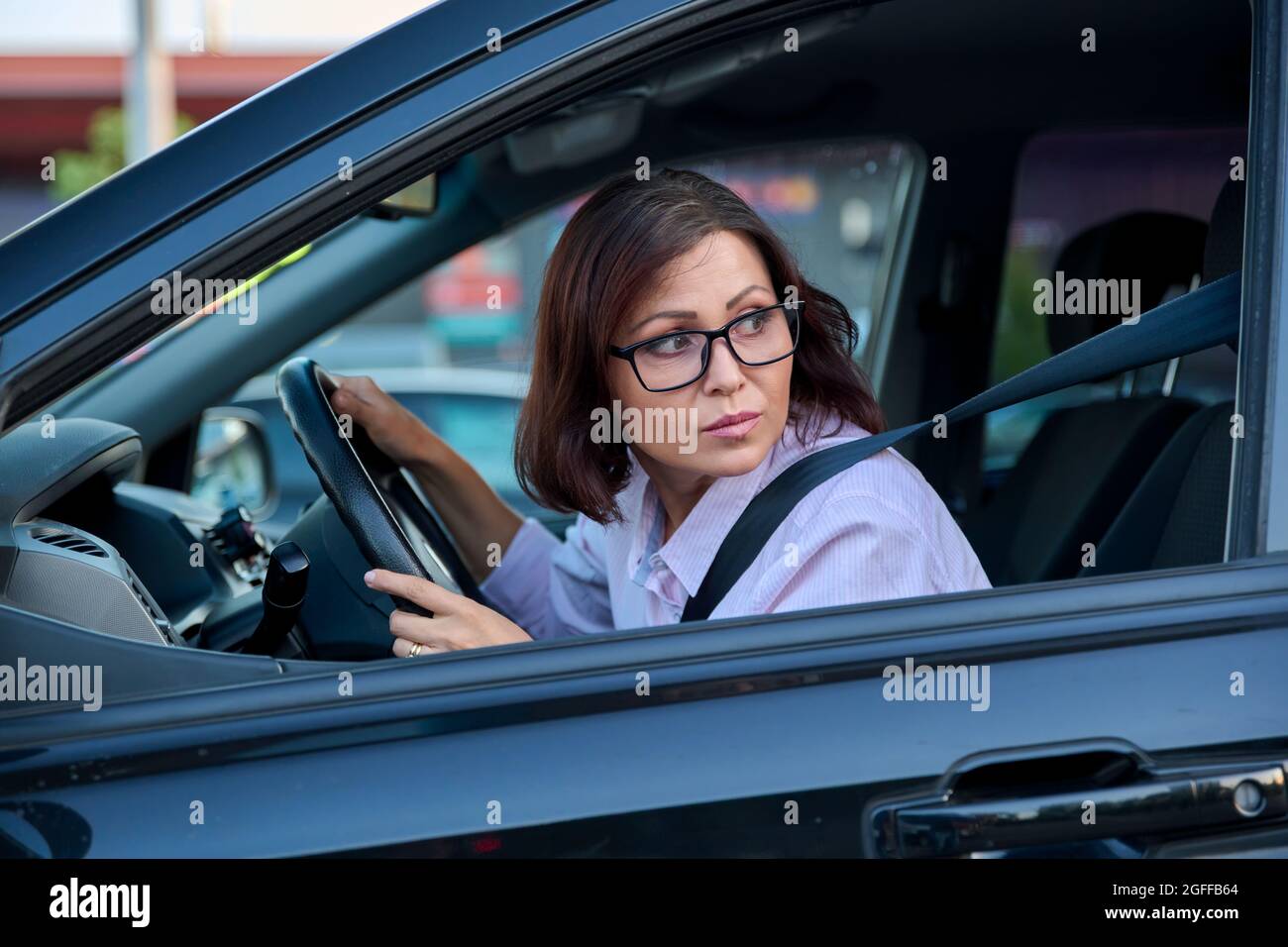 Middle-aged beautiful woman driver driving a car Stock Photo - Alamy