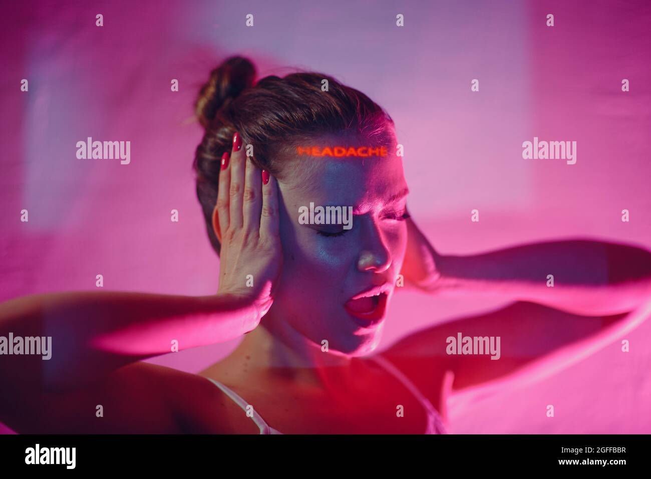 Young adult woman holds hands on head ad having suffering facial ...