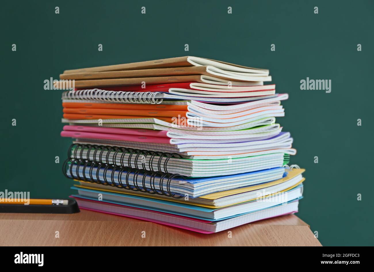 Stacked school notebooks on blackboard background Stock Photo - Alamy