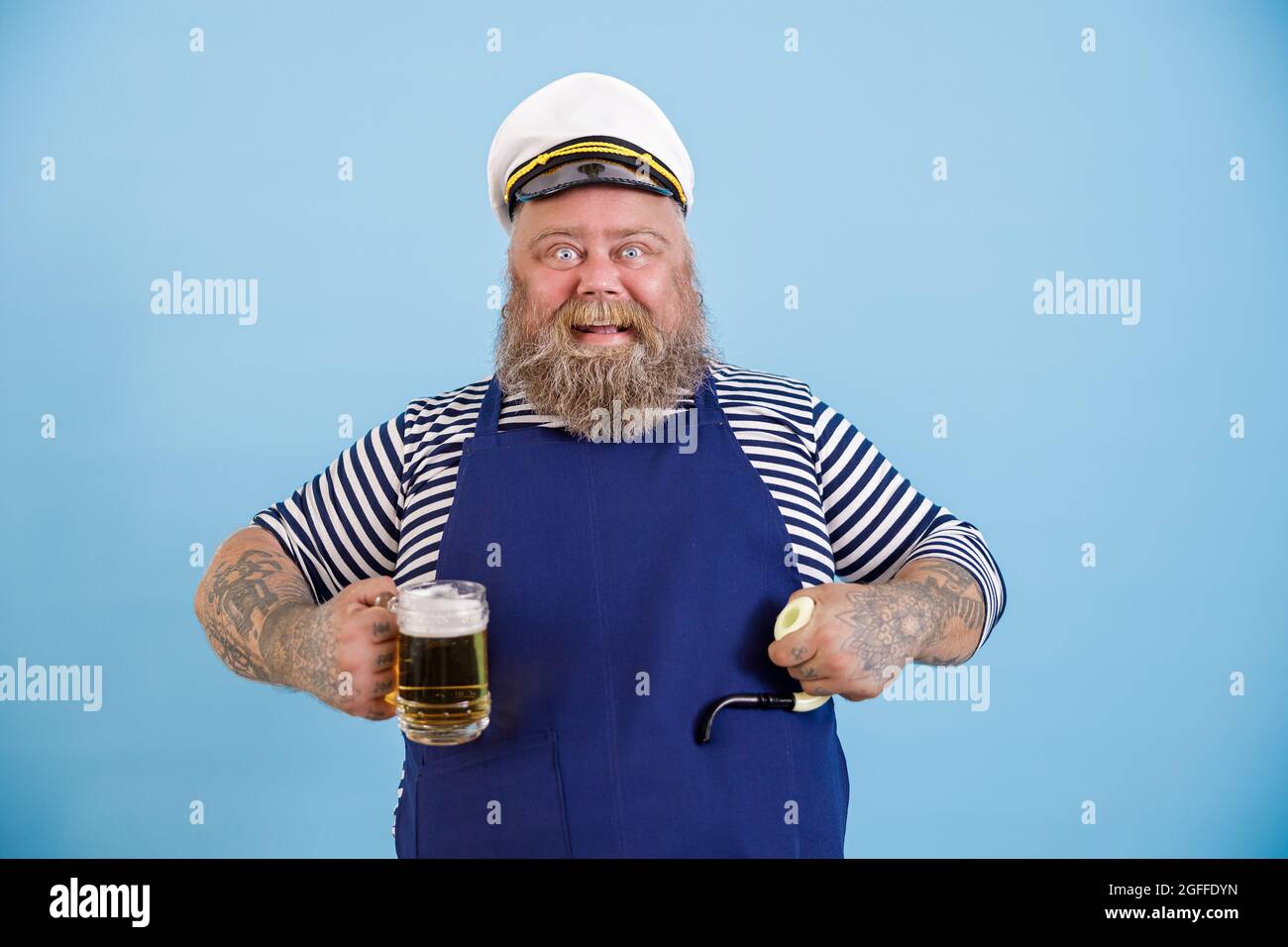 Funny plump person in sailor costume holds smoking pipe and beer on ...