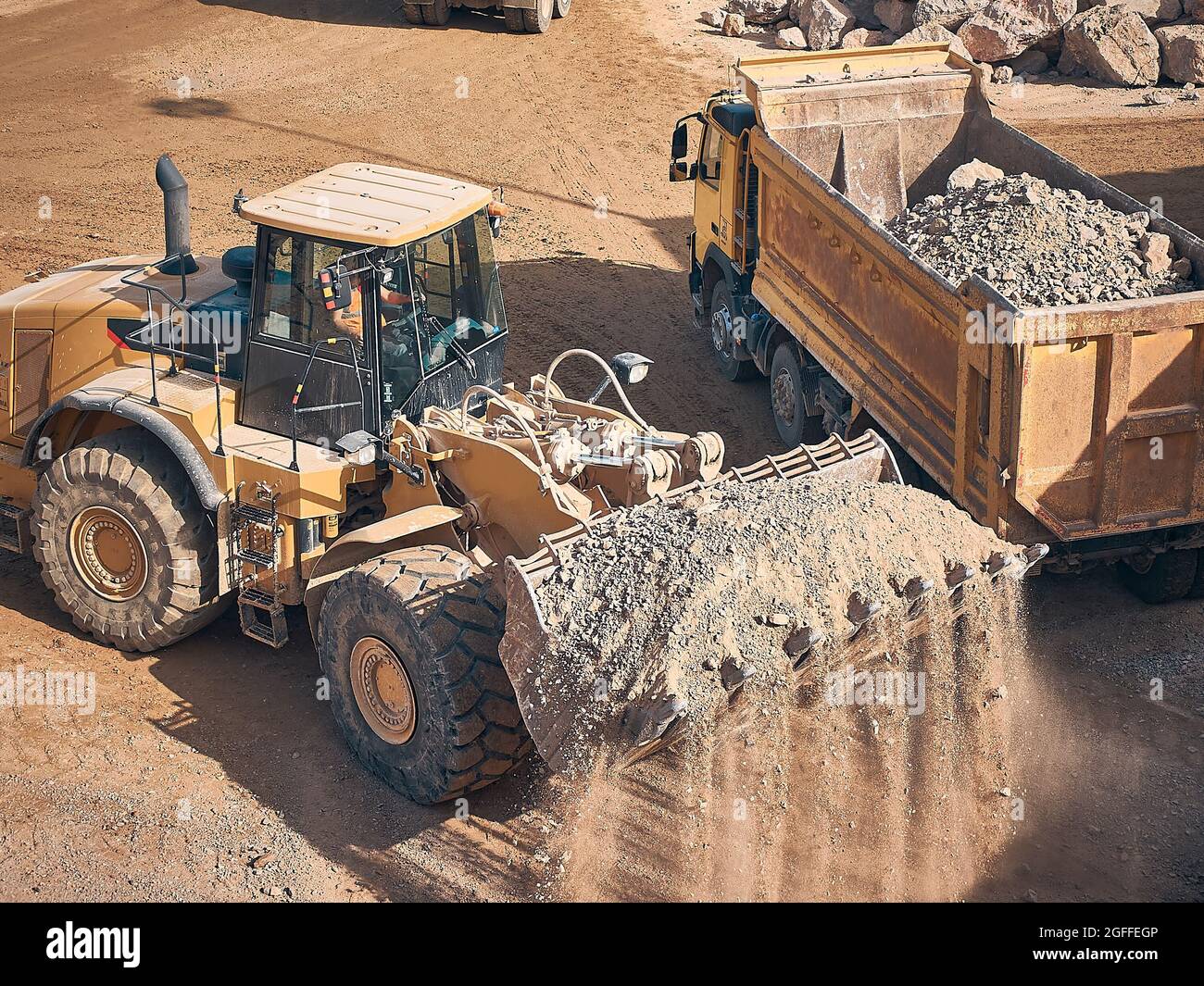 Wheel loader loads tipper with soil Stock Photo - Alamy