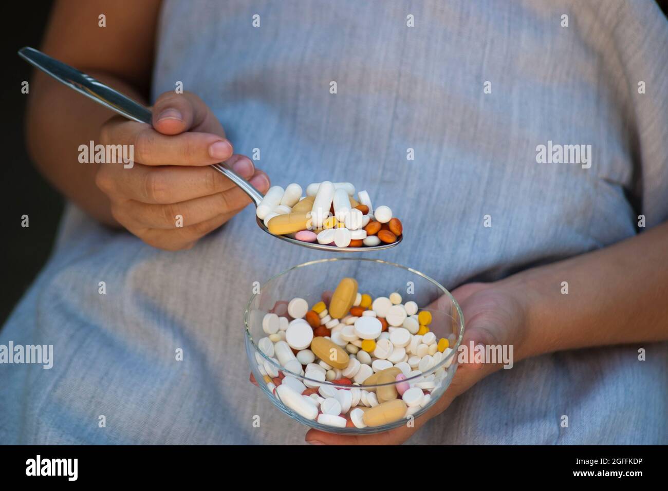 Taking medication with a tablespoon from a glass Stock Photo - Alamy