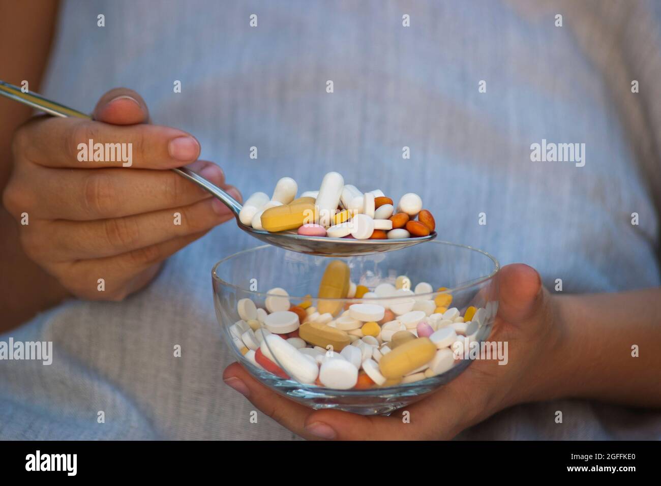 Taking medication with a tablespoon from a glass Stock Photo - Alamy
