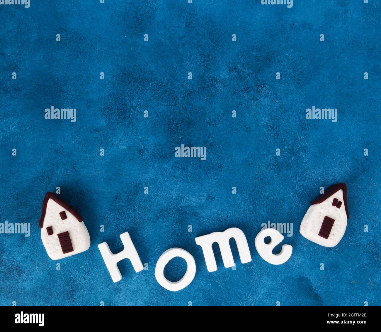 White letters HOME and polymer clay houses on a blue background. Copy ...