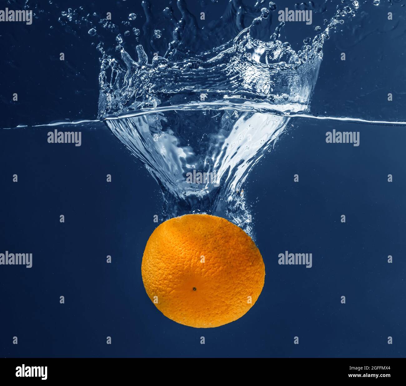 Fresh juicy orange falling in water on dark background Stock Photo - Alamy