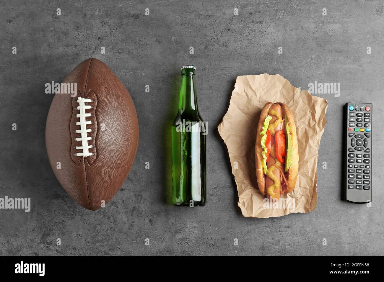 TV remote control, beer and ball on gray background Stock Photo - Alamy