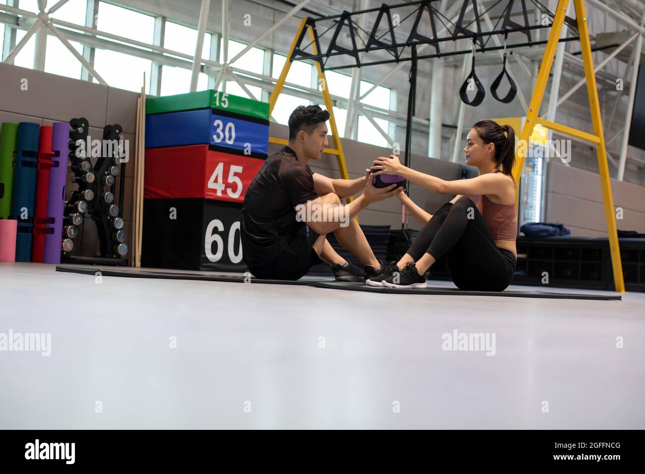 Young woman working out with personal trainer at gym Stock Photo - Alamy