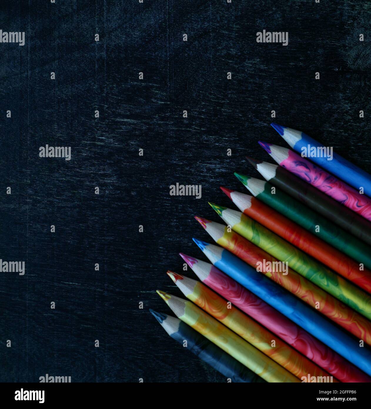Bright colored pencils on dark background. Blackboard and educational ...