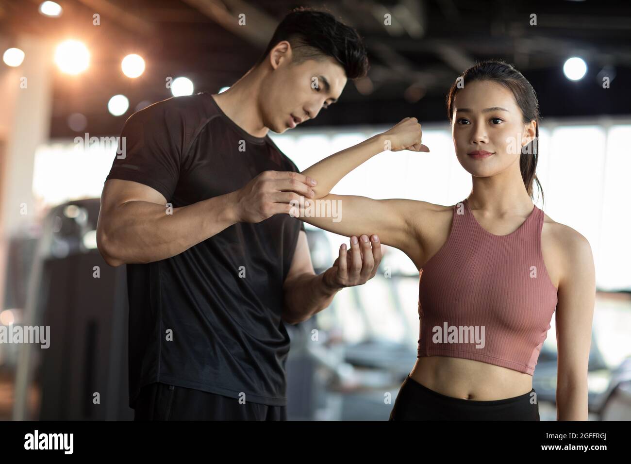 Young woman working out with personal trainer at gym Stock Photo - Alamy