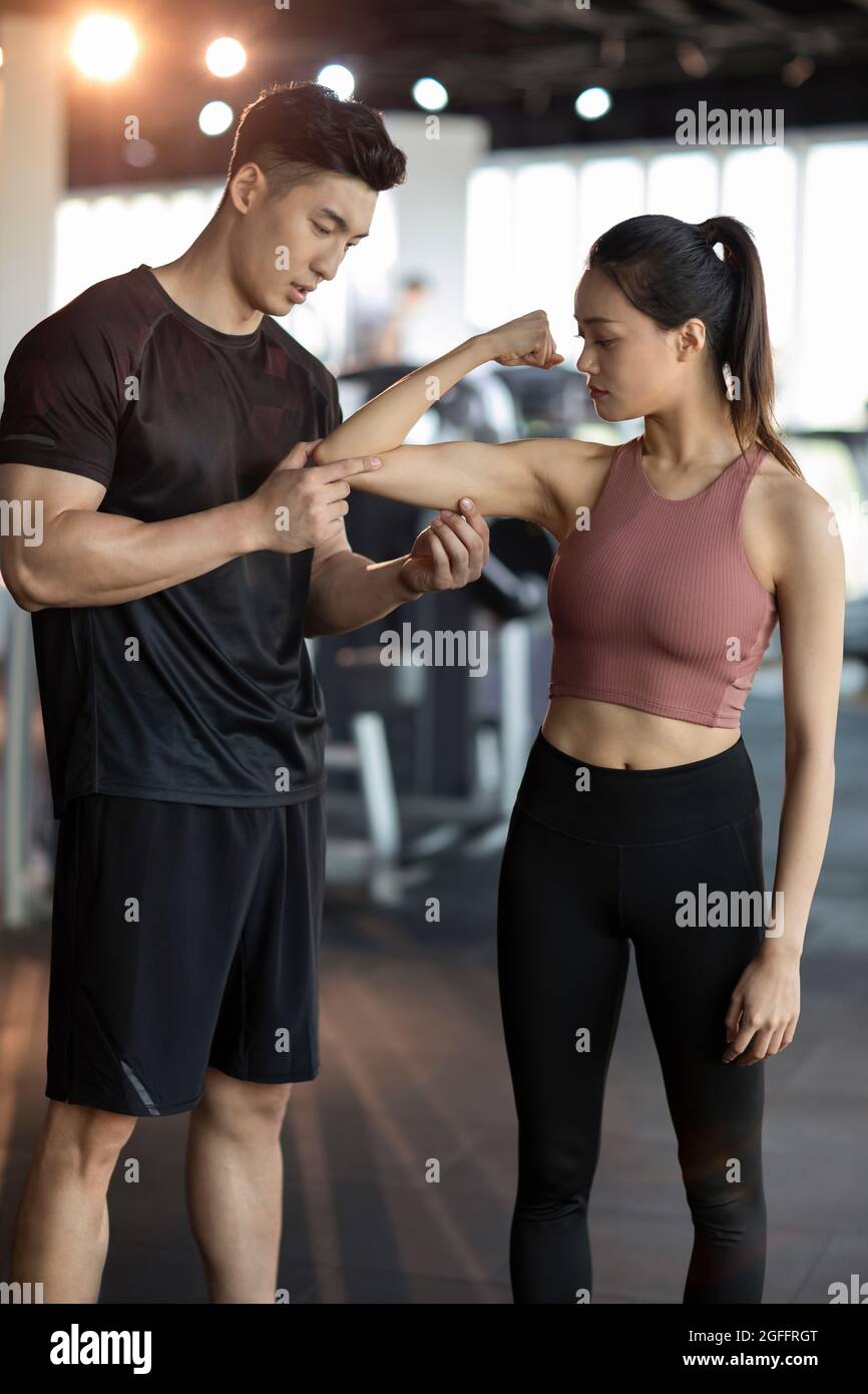 Young woman working out with personal trainer at gym Stock Photo - Alamy