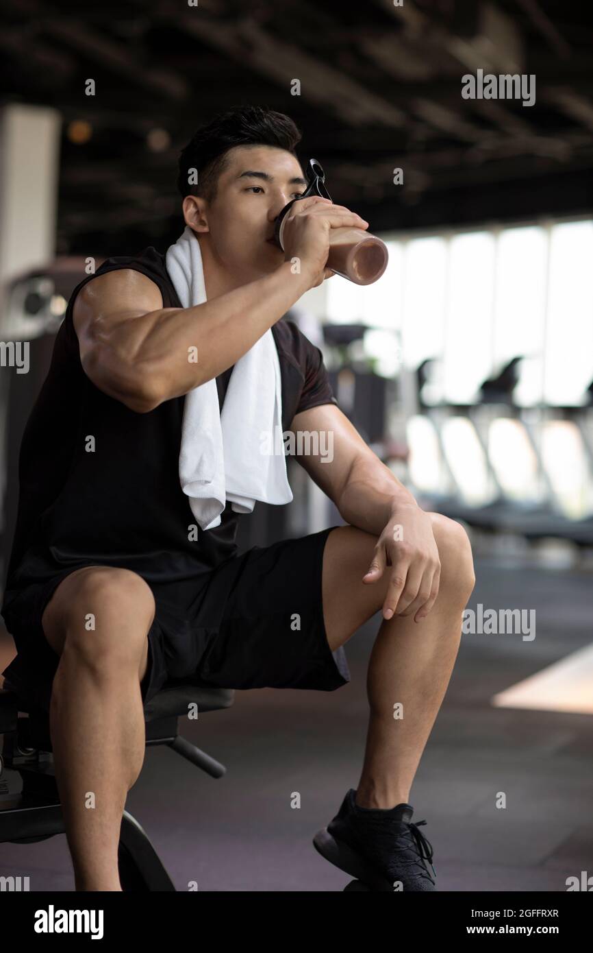 Young man taking a break from workout at gym Stock Photo - Alamy