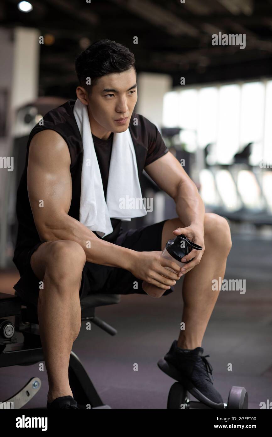 Young man taking a break from workout at gym Stock Photo - Alamy