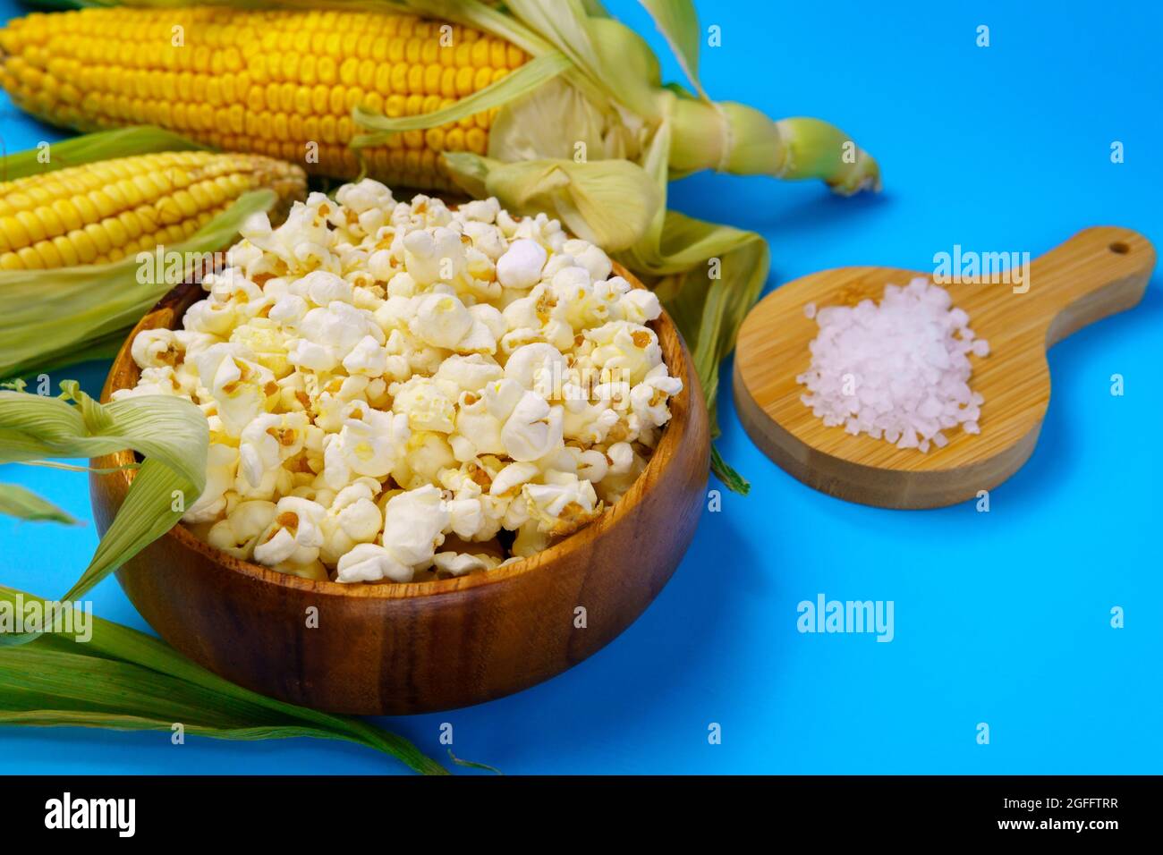 Corn on the cob, popcorn on a blue background. Topic - agro, corn ...
