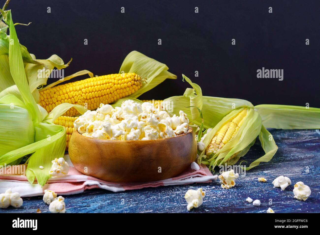 Fresh corn and popcorn on cobs on black background. close up. Copyspace ...
