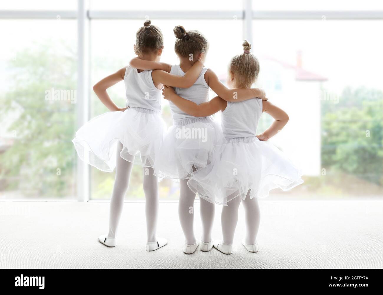 Cute girls looking out window in ballet class Stock Photo - Alamy