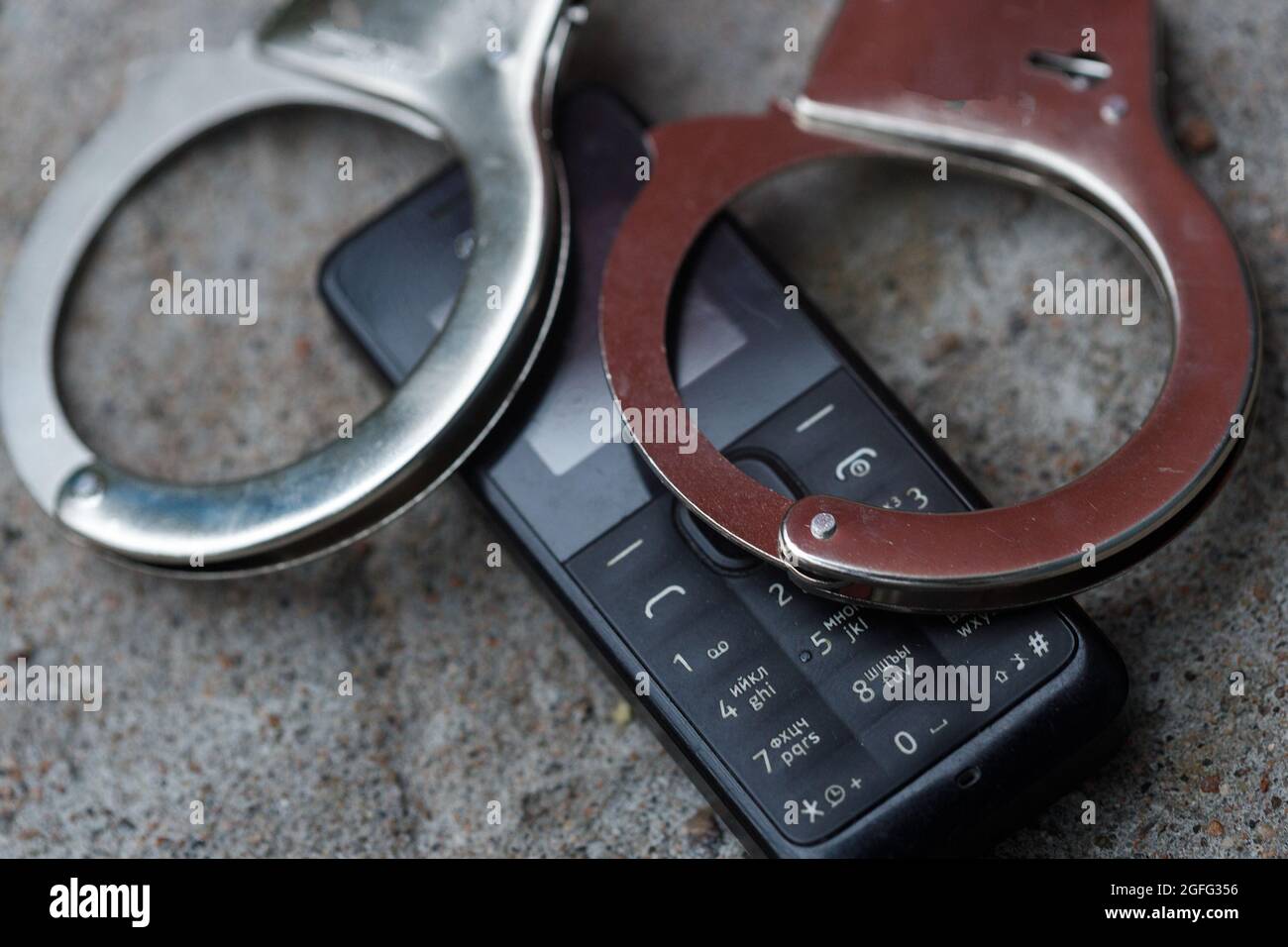 handcuffs lie on a cell push-button telephone. phone fraud concept ...