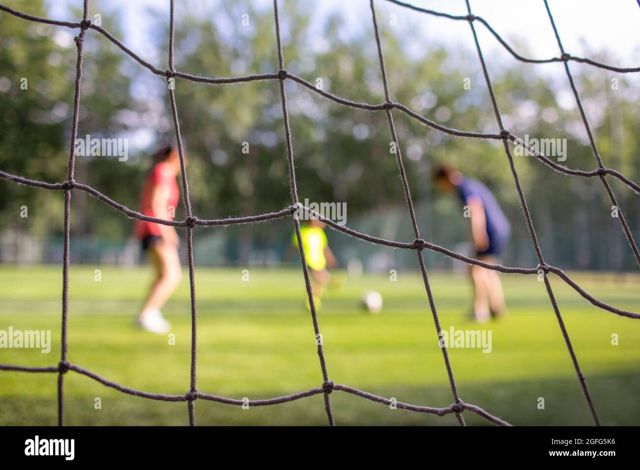Young family playing football on soccer field Stock Photo - Alamy