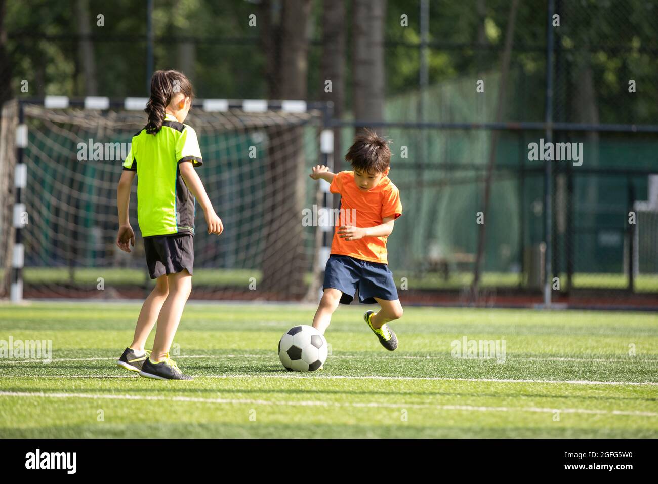 Children playing football on field Stock Photo - Alamy