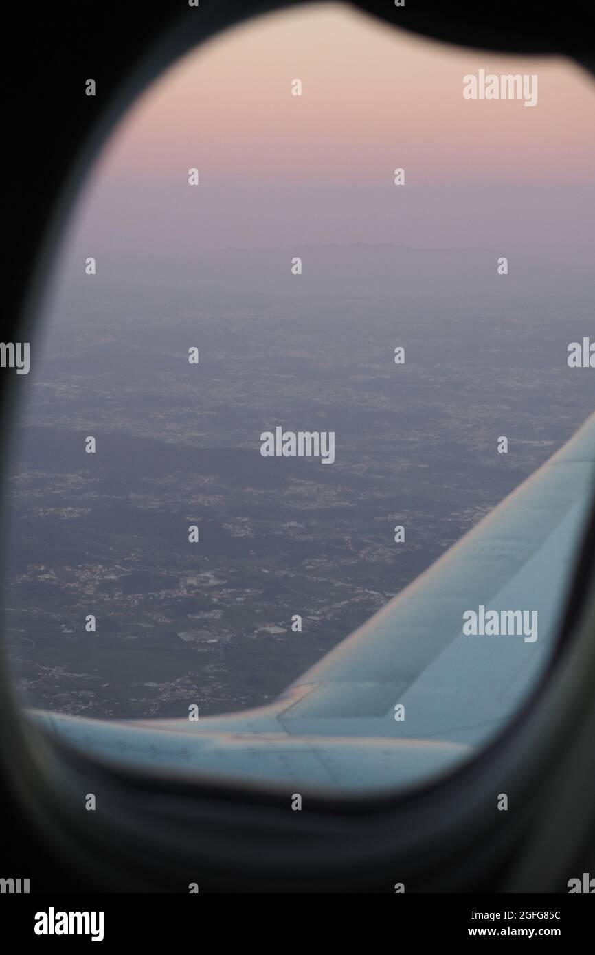 Sunset through the window of an airplane taking off from Porto ...