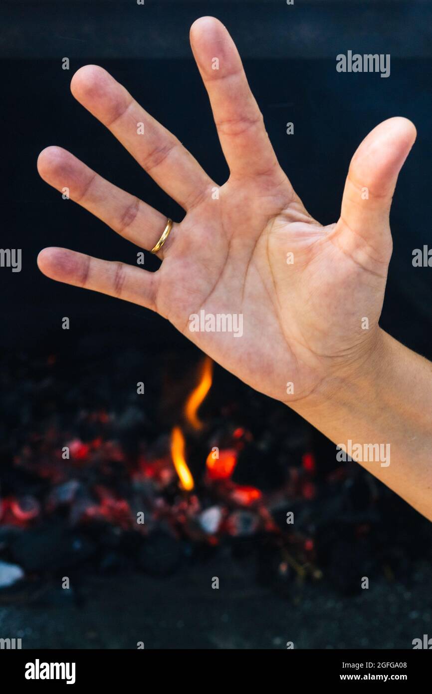 detail of a hand with the stop gesture when preparing a fire for a ...