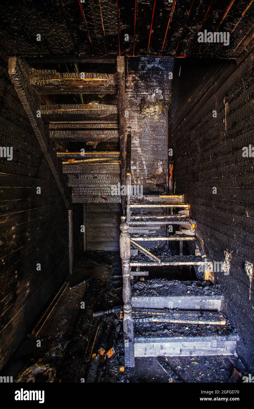 Burnt wooden house interior. Charred stairs and walls. Consequences of ...