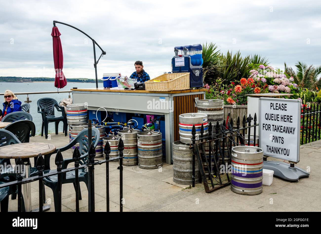 An outdoor bar on The Esplanade in Tenby, Wales on an overcast day in ...