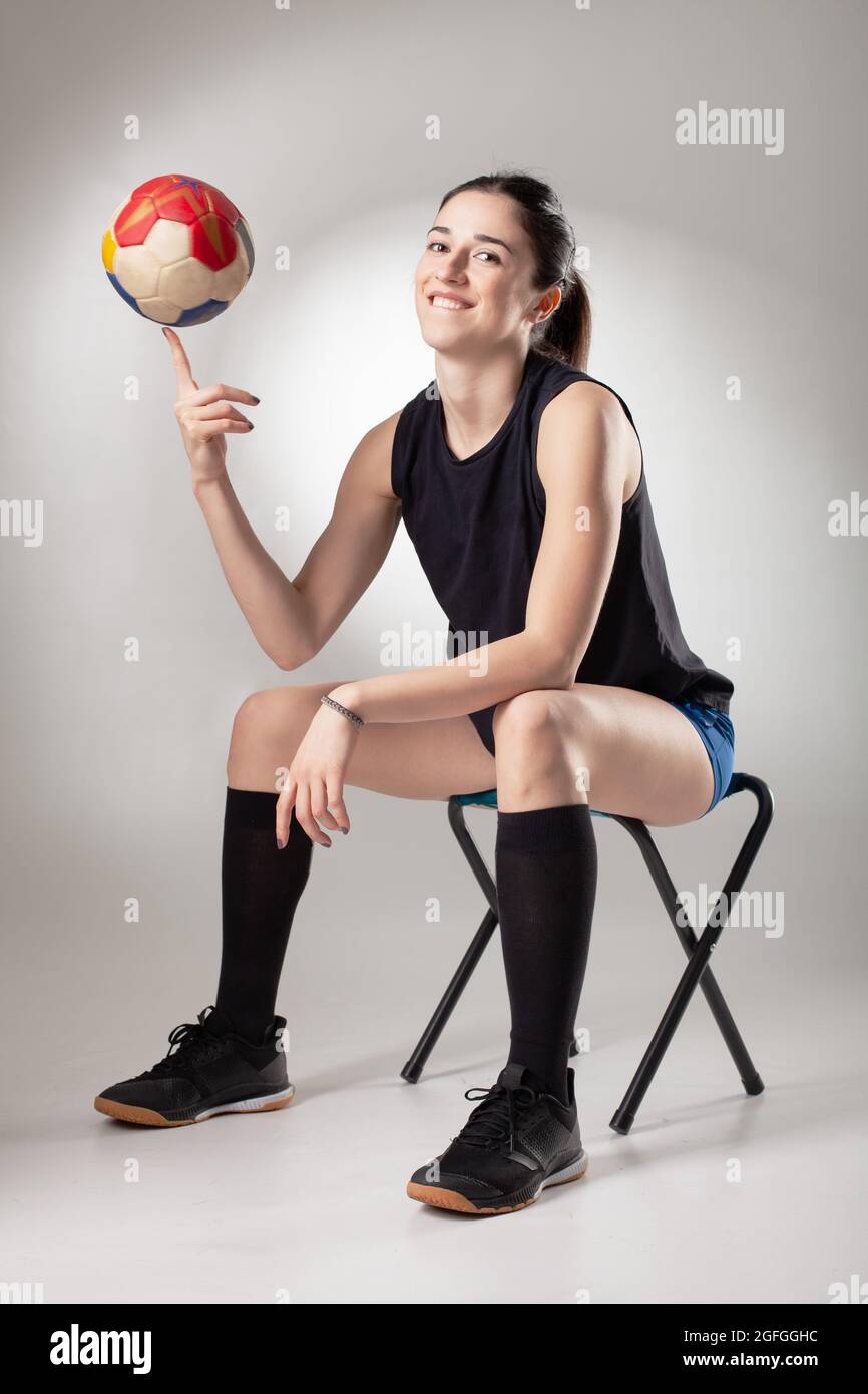 Handball player sitting on a chair. Female posing with ball Stock Photo ...
