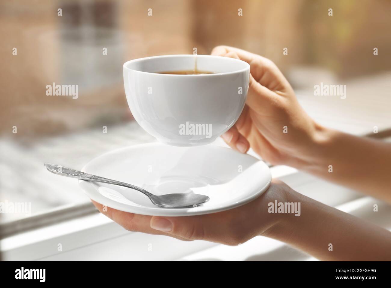 Female hands holding cup of tea Stock Photo - Alamy