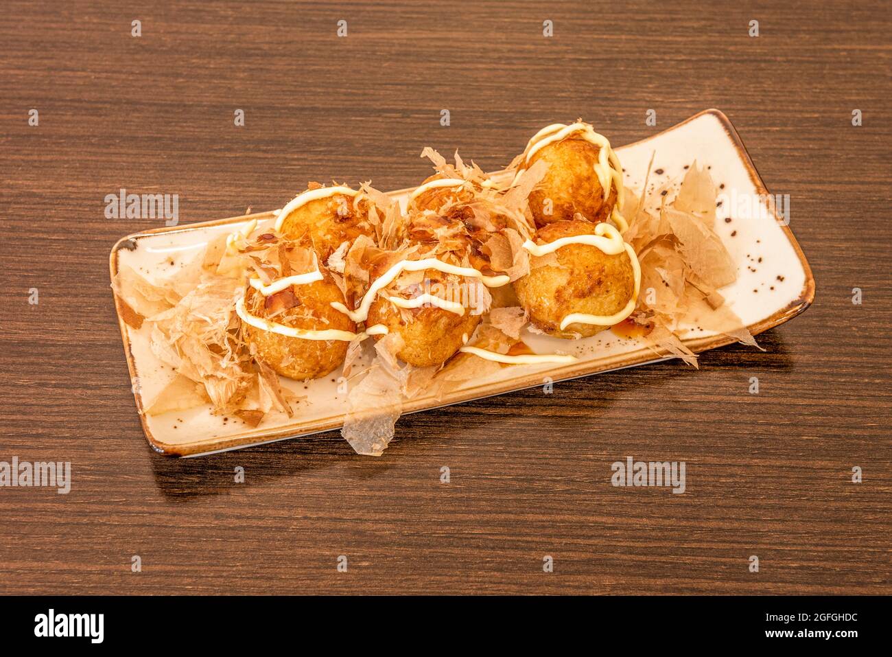 Japanese-style octopus takoyaki with red tuna scales and sauce on a ...