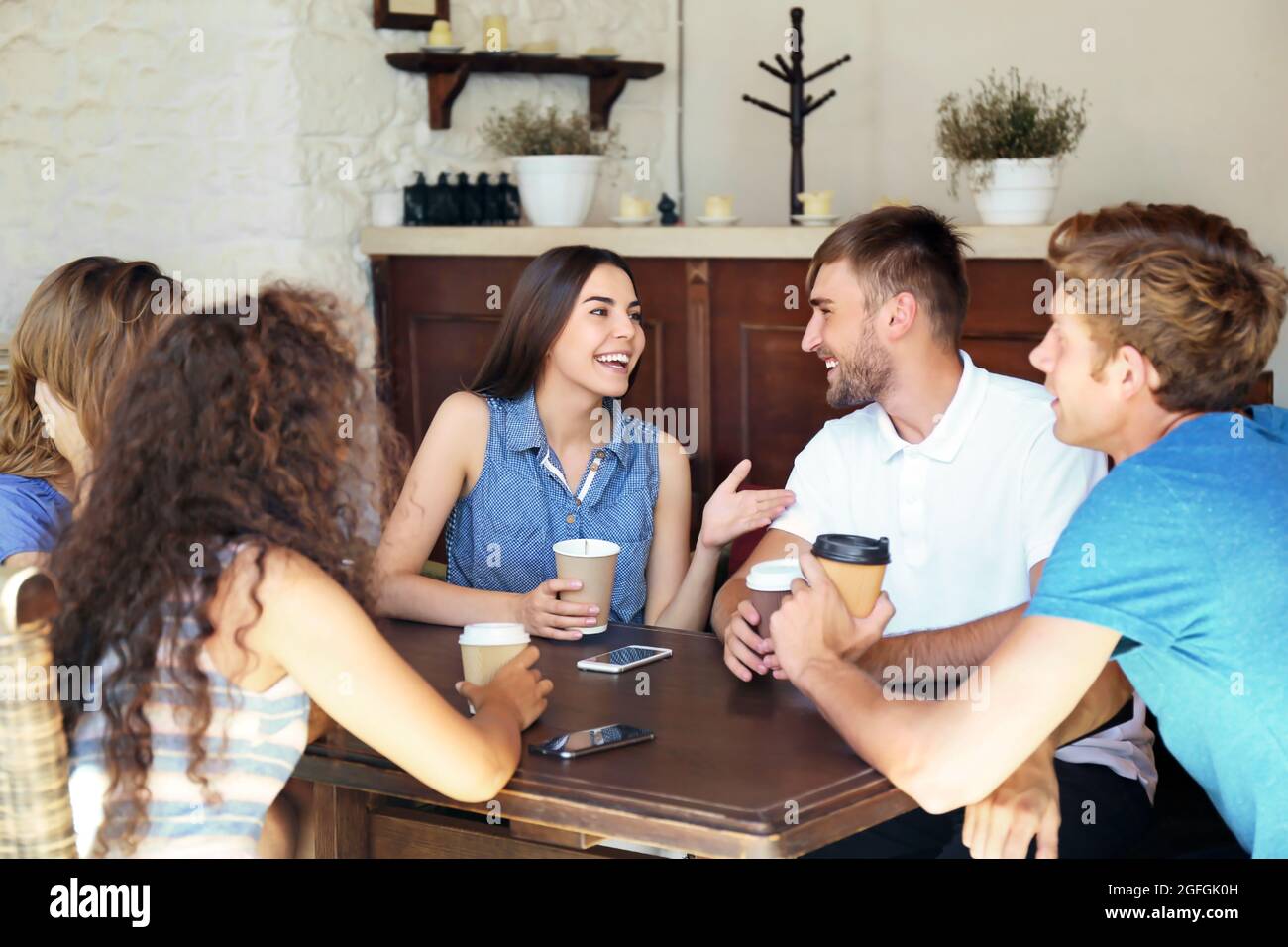 Happy friends drinking coffee in cafe Stock Photo - Alamy