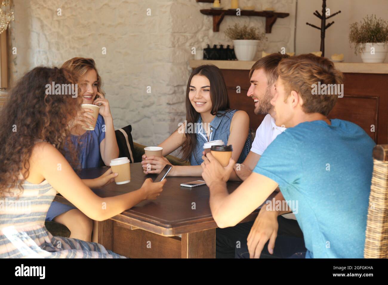 Happy friends drinking coffee in cafe Stock Photo - Alamy