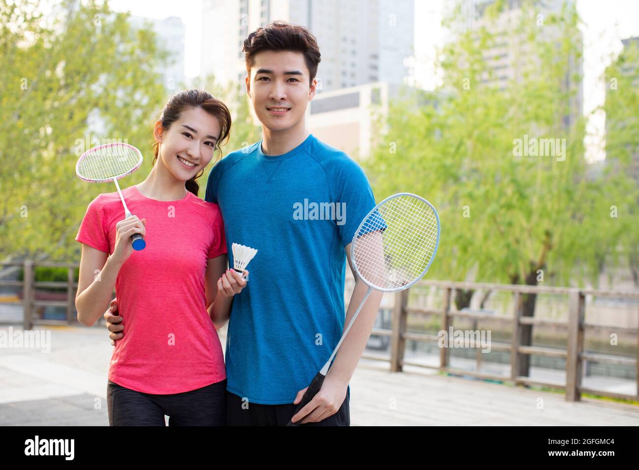 Happy young couple playing badminton in park Stock Photo - Alamy