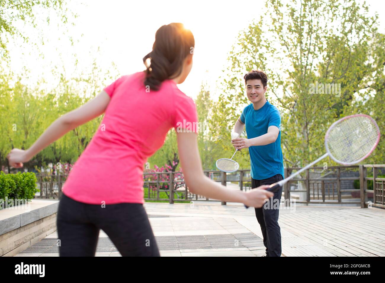 Happy young couple playing badminton in park Stock Photo - Alamy