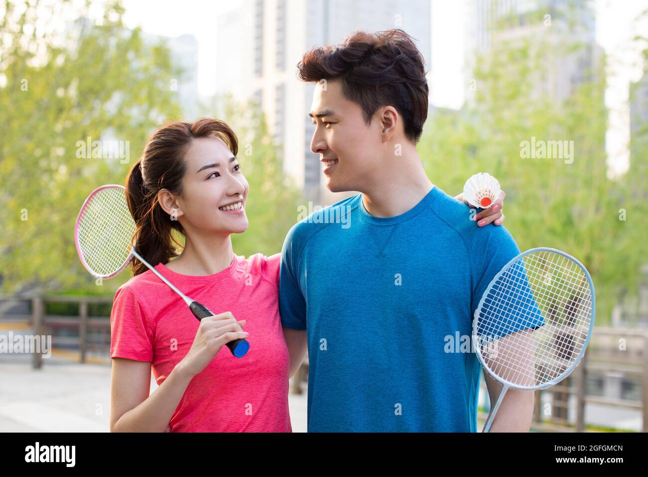 Happy young couple playing badminton in park Stock Photo - Alamy