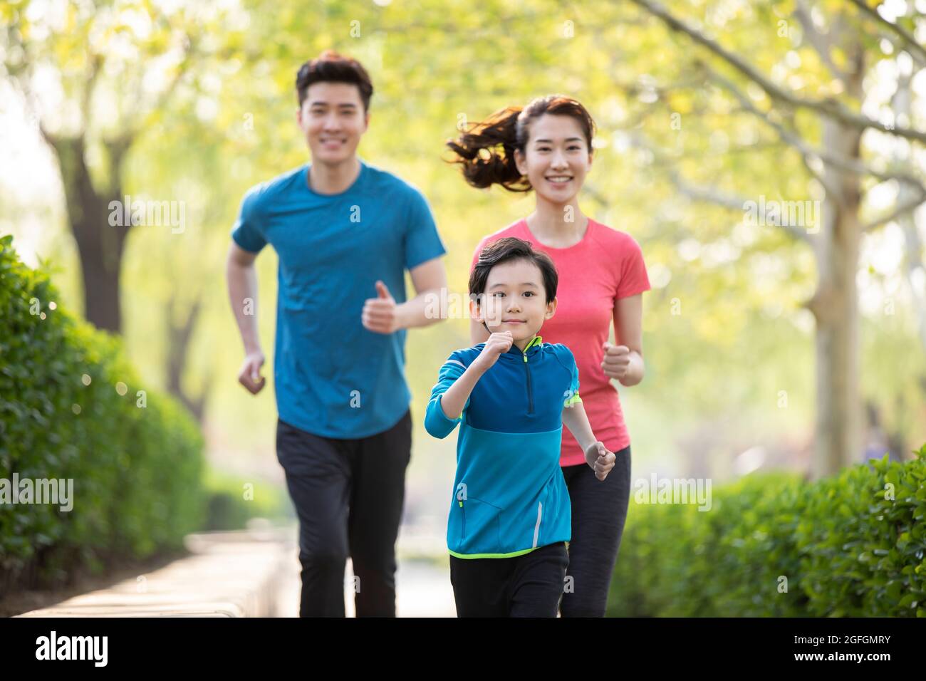 Happy young family running in park Stock Photo - Alamy