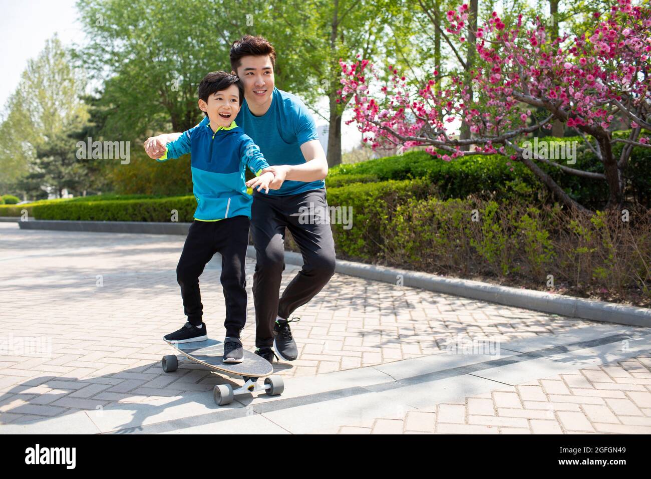 Father teaching his son to skateboard Stock Photo - Alamy