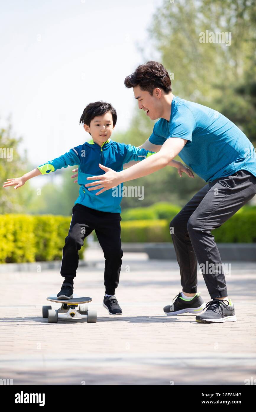 Father teaching his son to skateboard Stock Photo - Alamy