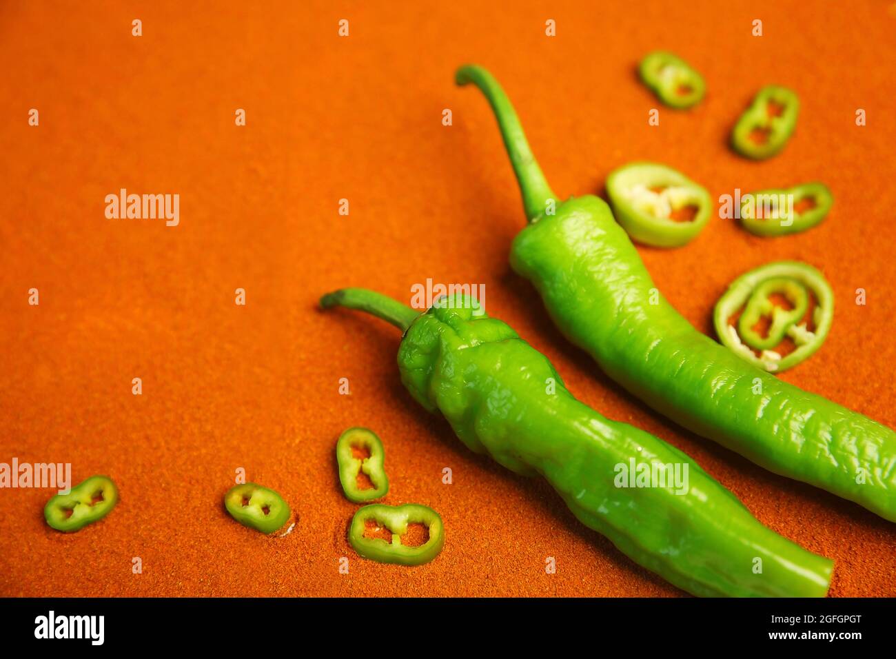 Green peppers on color spice background Stock Photo - Alamy