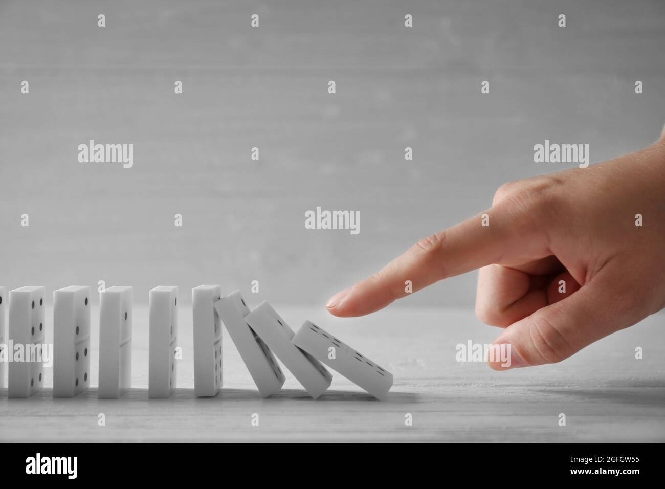 Hand pushing dominoes hi-res stock photography and images - Alamy