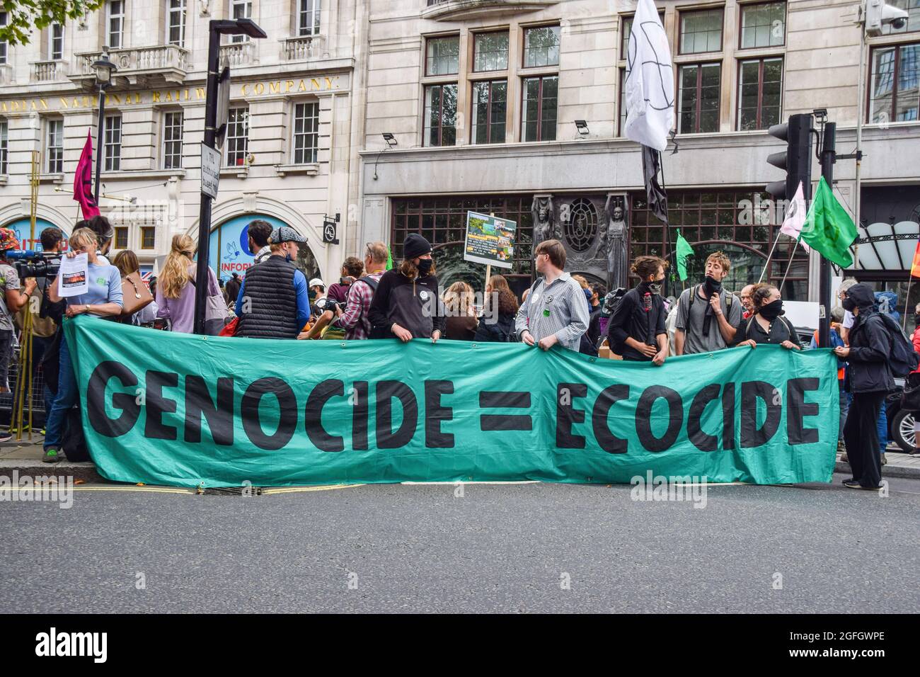 London, UK. 25th Aug, 2021. Protesters hold a "Genocide = Ecocide ...