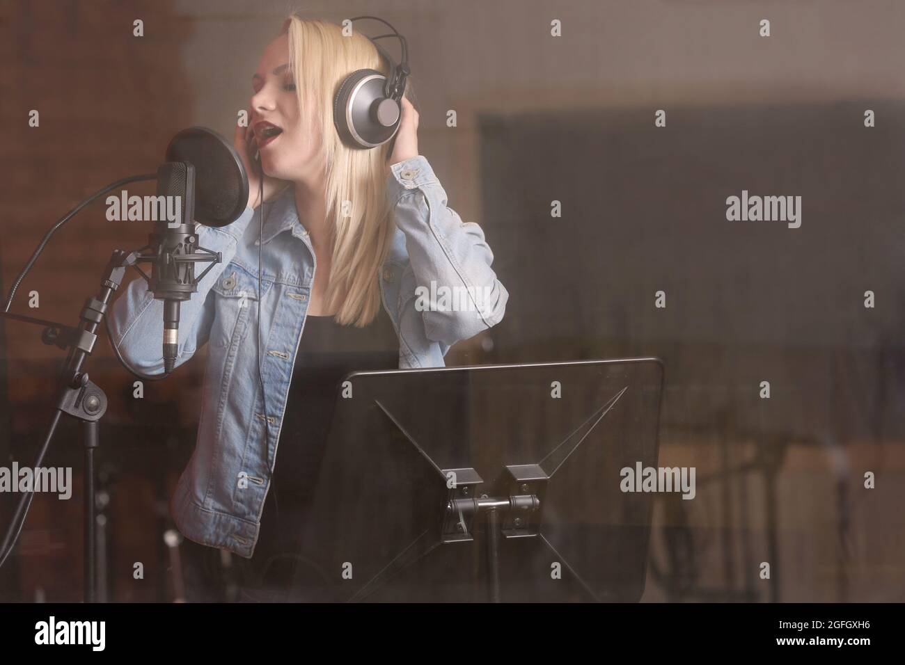 Young woman recording a song in a professional studio Stock Photo - Alamy