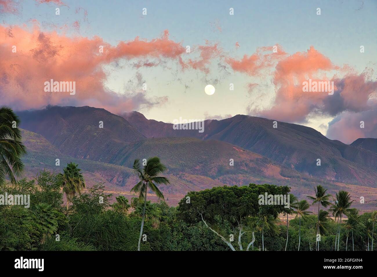 Full moon rising over the west maui mountains at sunset with pink puffy ...