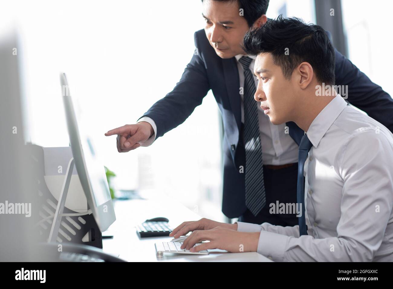 Confident businessmen using computer in office Stock Photo - Alamy