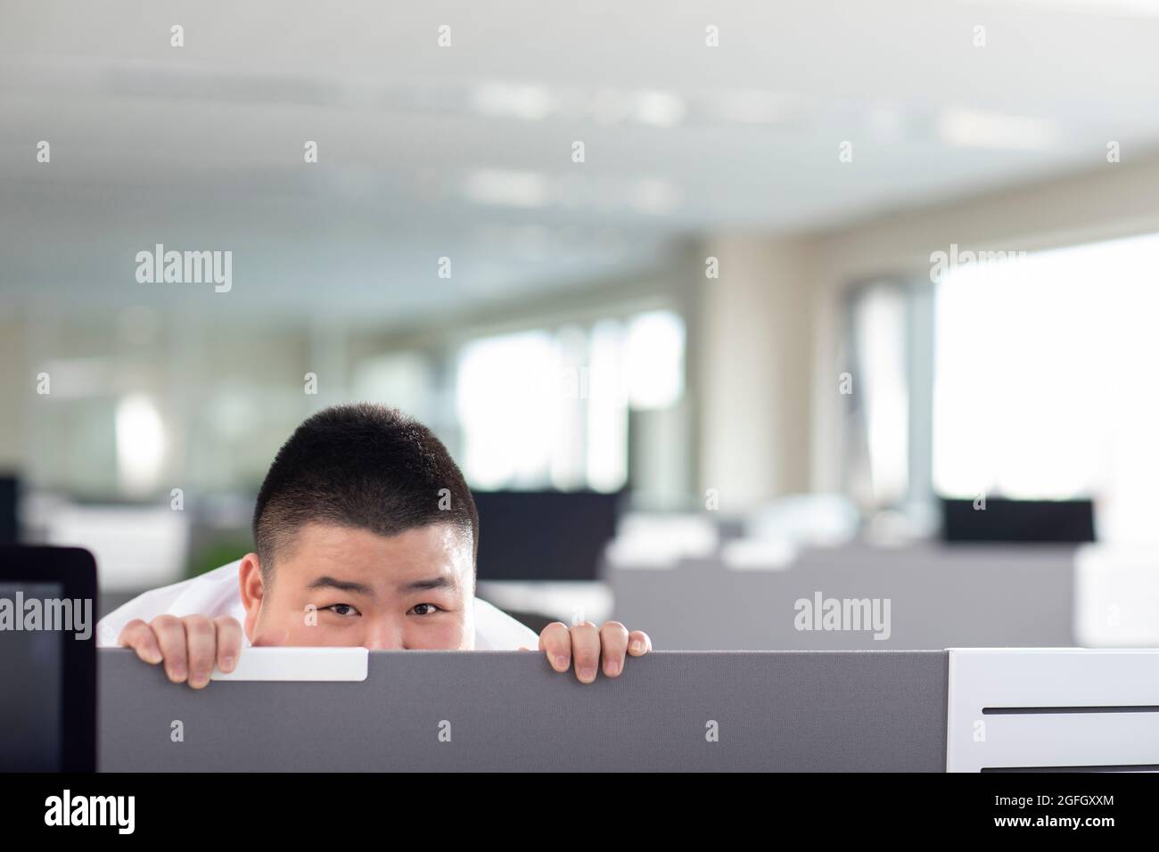 Young businessman peeking Stock Photo - Alamy