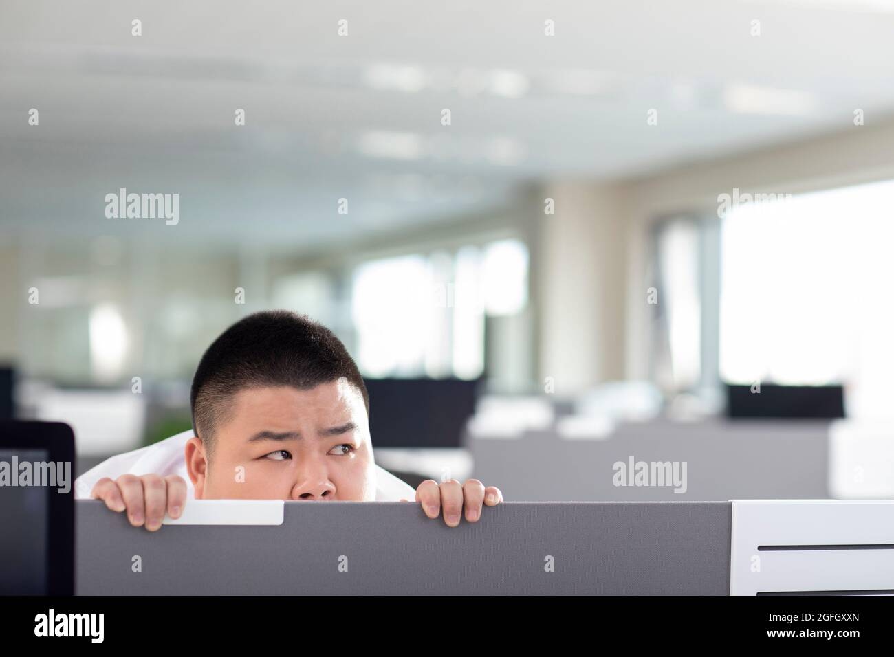 Young businessman peeking Stock Photo - Alamy