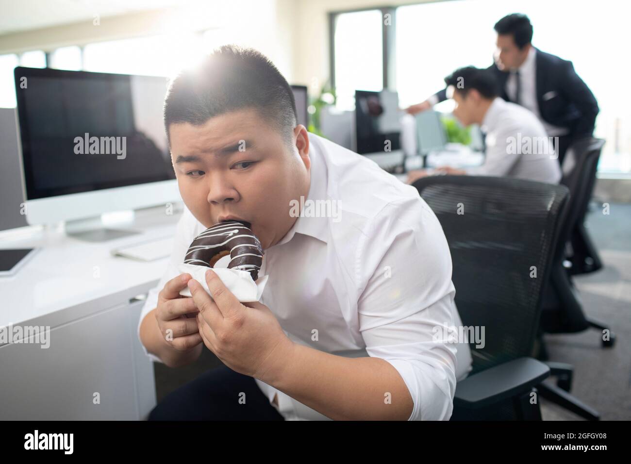 Office eating donut hi-res stock photography and images - Alamy